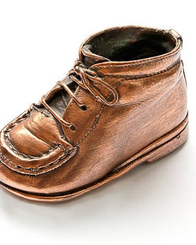 Single babyshoe on white background, bronze